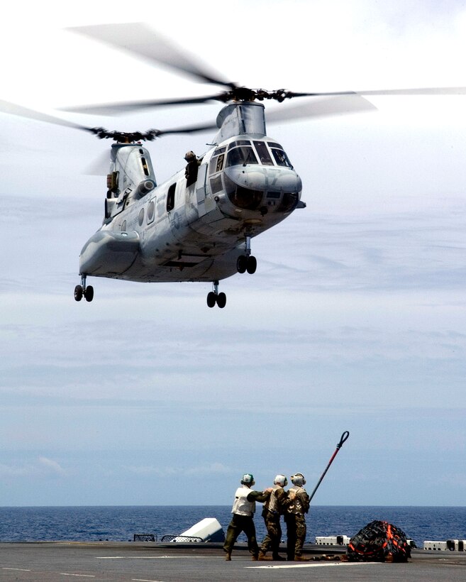 Cargo handlers onboard the USS Essex conduct cargo hook training with a ...