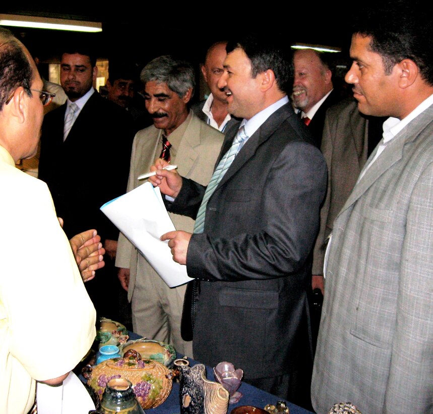 Baghdad Mayor Sabir al-Isawi talks with business owners during the ...