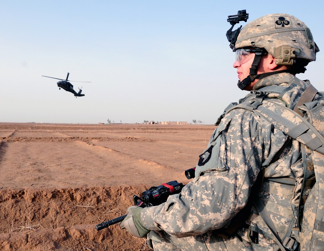 A U.S. Army soldier pulls security and watches as a UH-60 Black Hawk ...