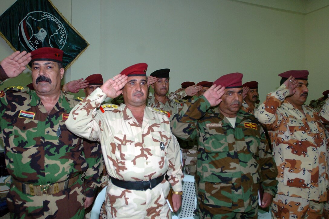 Iraqi soldiers salute during their national anthem at a ceremony ...