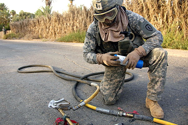 U.S. Army Sgt. David Alsup changes out the gas canister on a ...