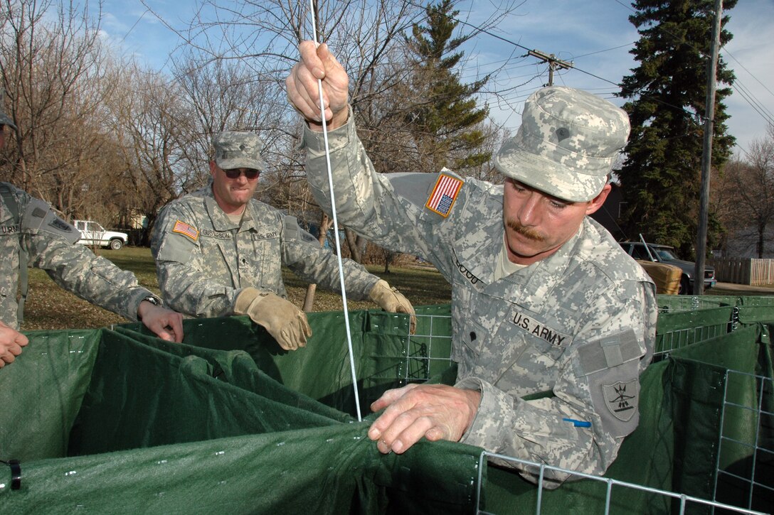 U.S. Army Spcs. Andrew Gustafson, left, and Loyal Good assemble flood ...