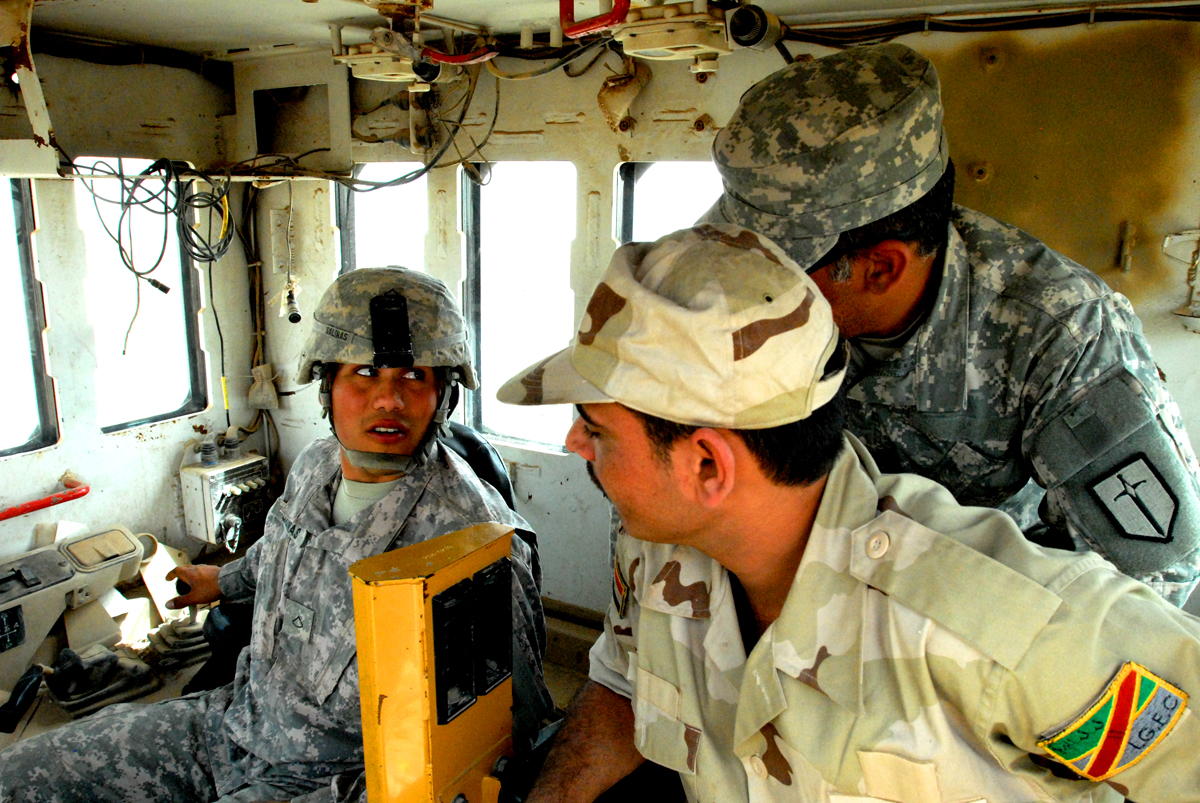 Army Pfc. Eric Salinas, left, explains controls and maneuvers in the ...