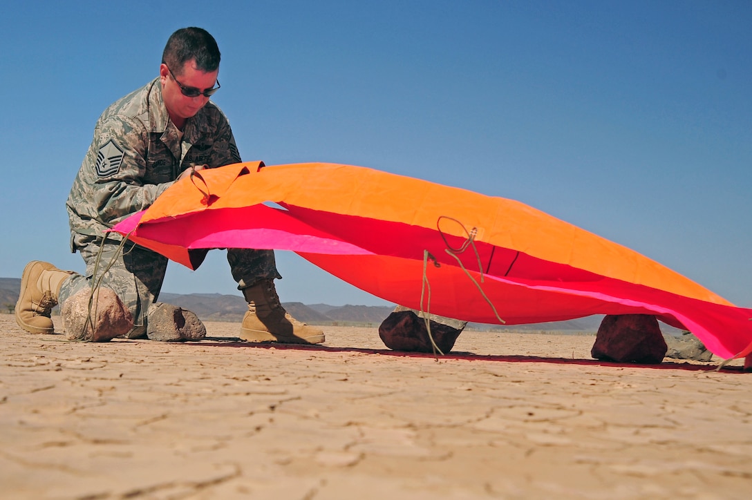 U.S. Air Force Master Sgt. Robert Grande places VS-17 panels to mark ...