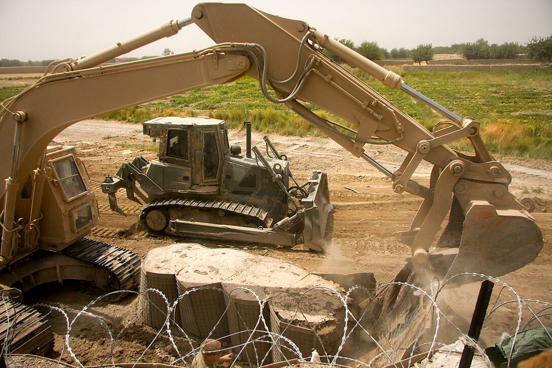 U.S. Marines use heavy equipment to flatten the ground to build new ...