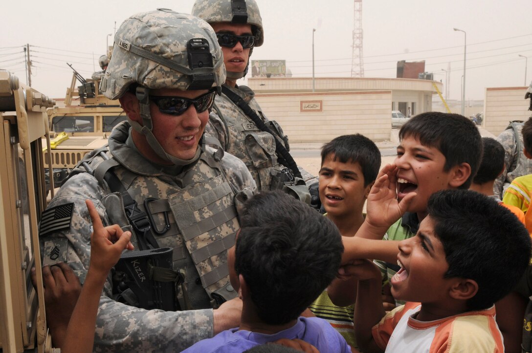 U.S. Army Staff Sgt. Victor Kizer passes out toys to local Iraqi ...