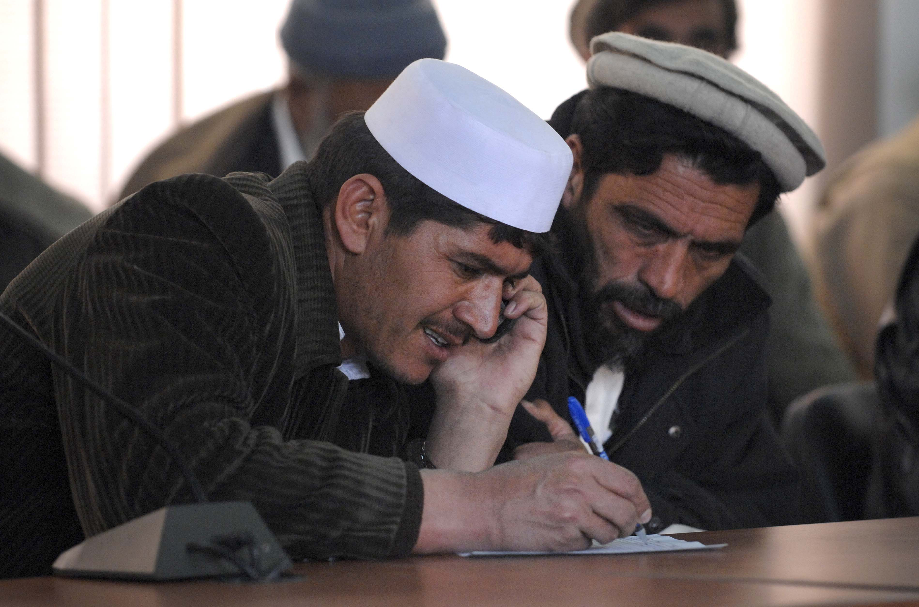 Two local contractors list their contact information on a sign-in sheet ...