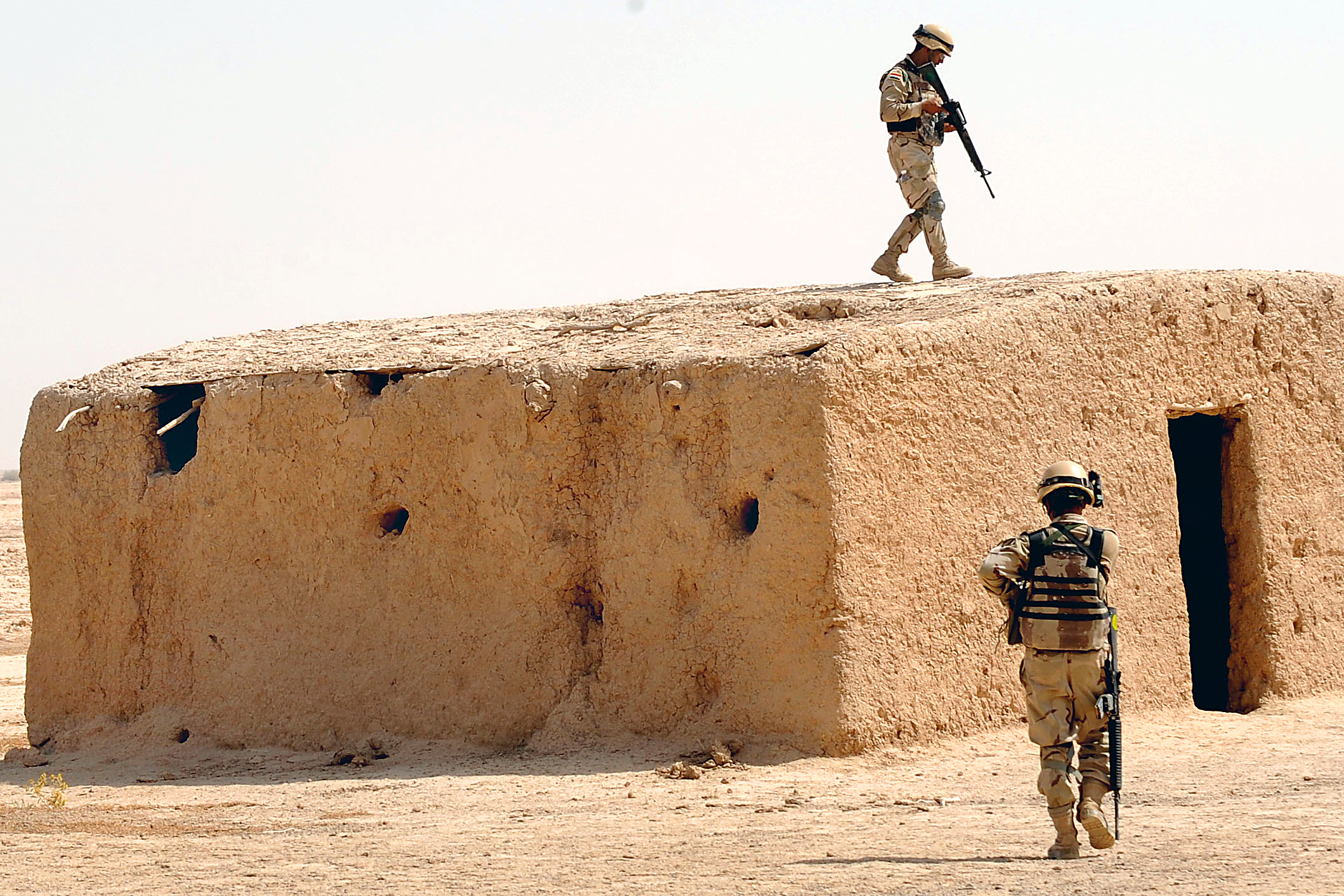 An Iraqi soldier checks the roof of a building during a joint air ...