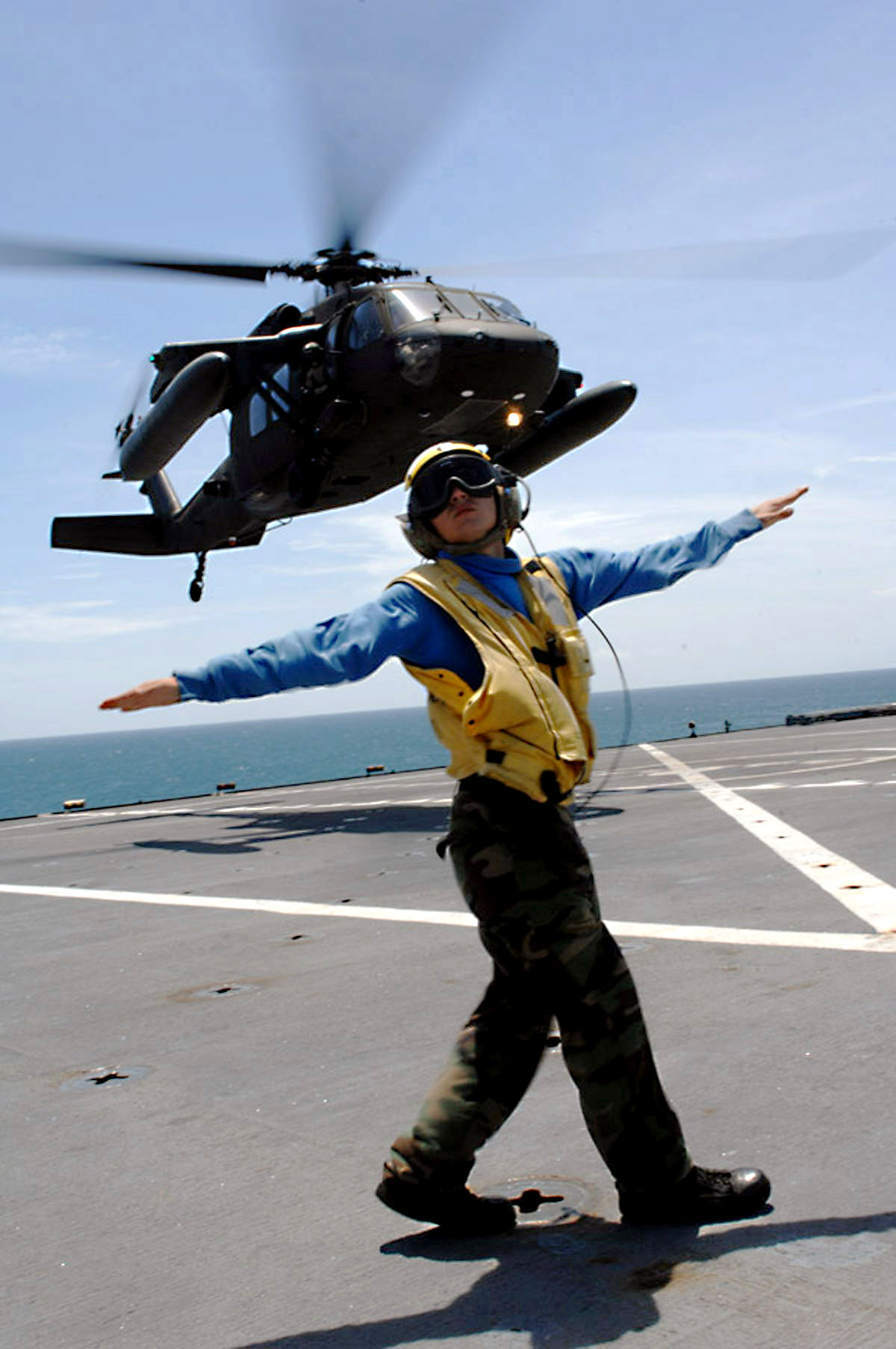 U.S. Navy Petty Officer 3rd Class Matthew Shaw directs a UH-60 Army ...