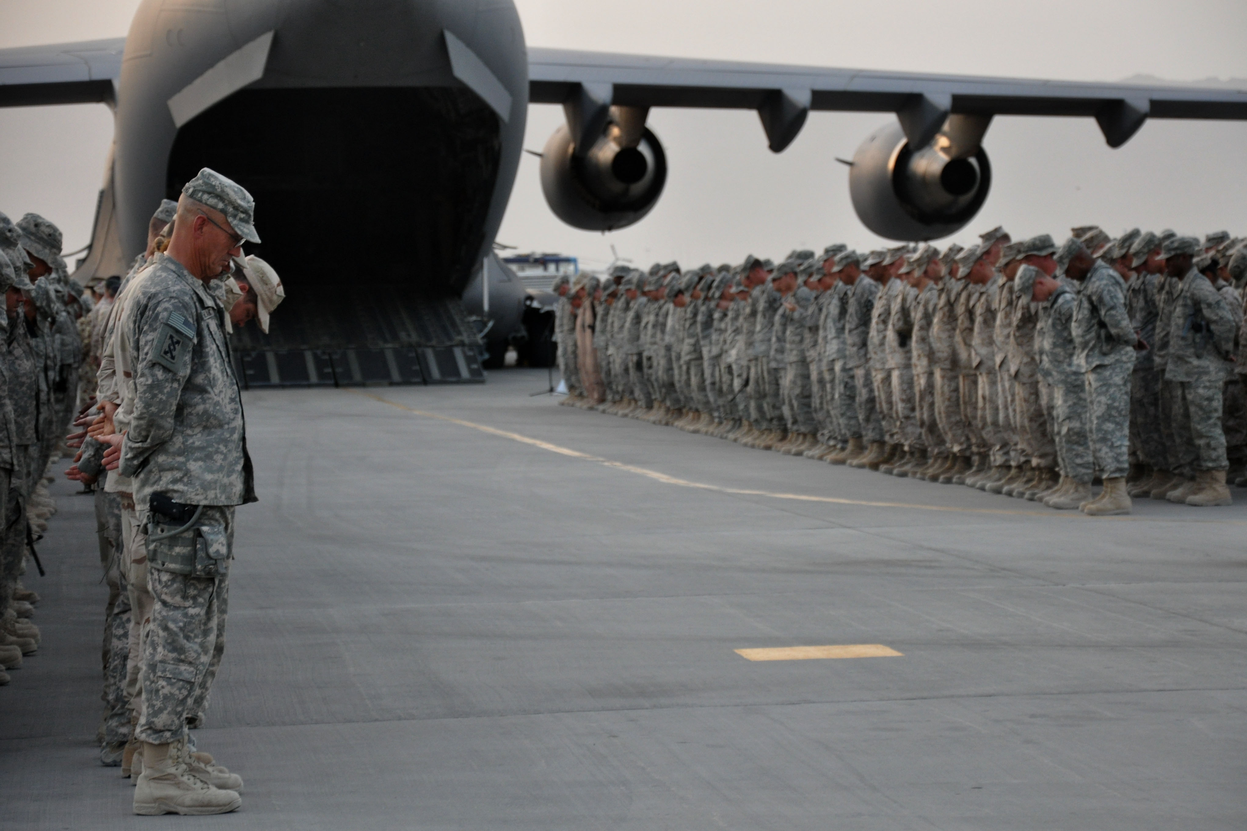 Troops bow their heads during a chaplain’s prayer during transfer of a ...