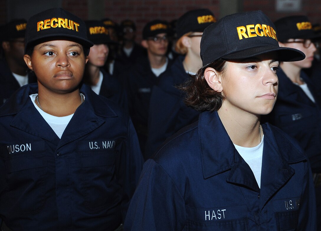 U.S. Navy basic training recruits stand at attention awaiting the ...