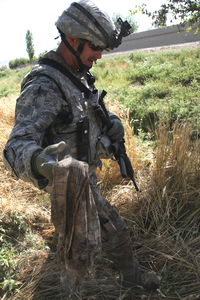 U.S. Air Force Staff Sgt. Carl Dill collects the bag that covered an ...