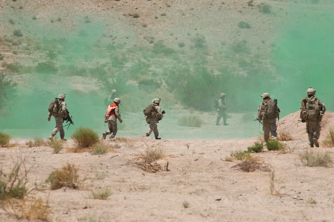 U.S. Marines move under cover of green smoke to firing positions under ...