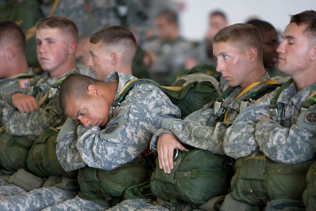 U.S. paratroopers wait in harnesses on Pope Air Force Base’s green ramp ...