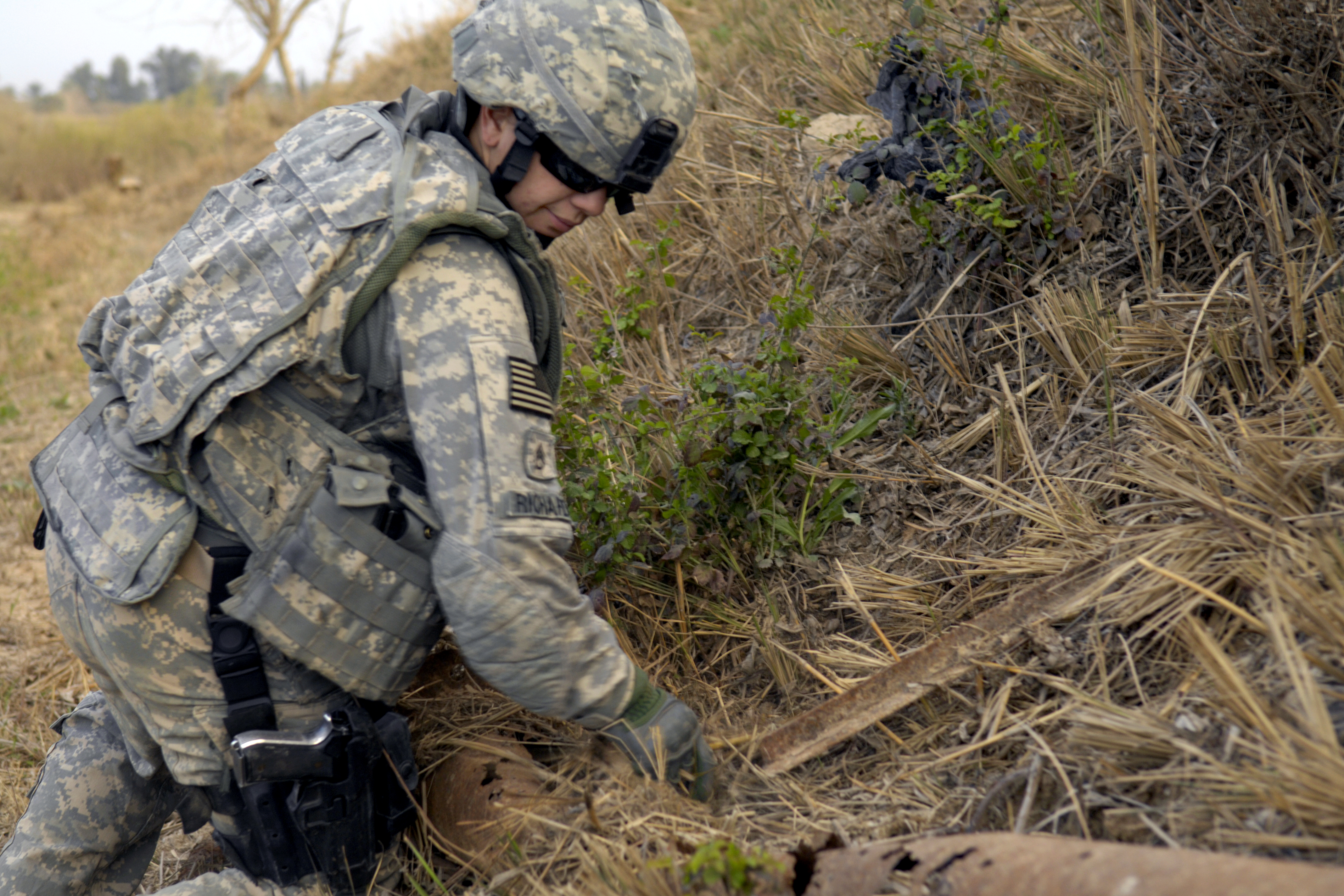 U.S. Army Staff Sgt. Tasia Richards examines a secondary munitions site ...