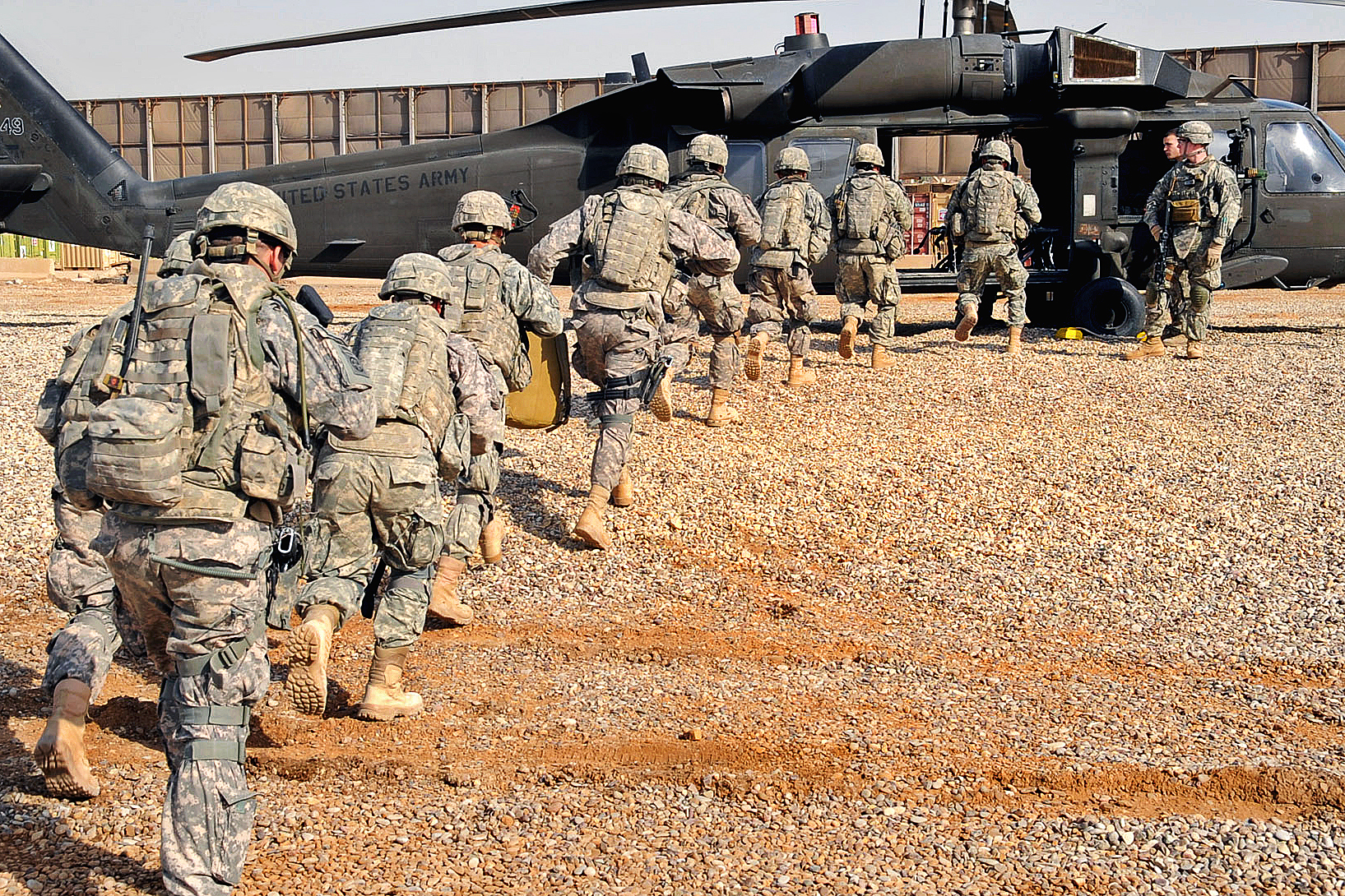 U.S. Army soldiers run toward a UH-60 Black Hawk helicopter during an ...