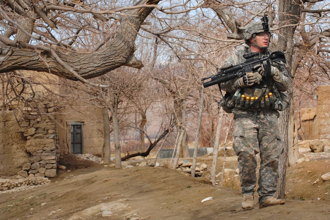 U.S. Army Sgt. Joseph Redhair clears a wooded area outside a village in ...