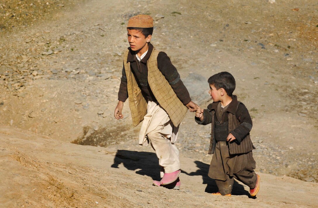 Two small boys make their way up a hill toward the main section of the ...
