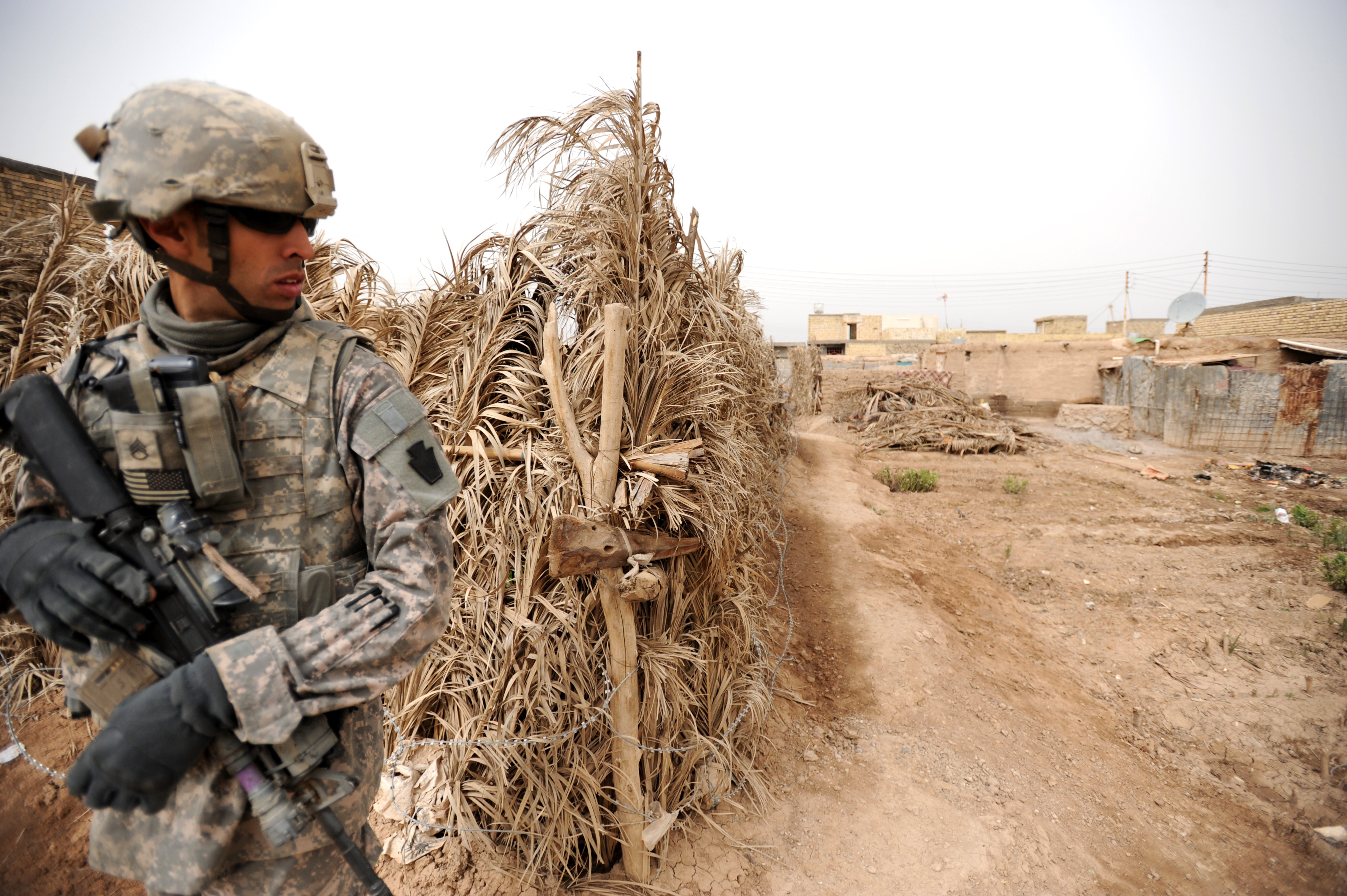 U.S. Army Staff Sgt. Matthew Kilner checks around a corner while ...