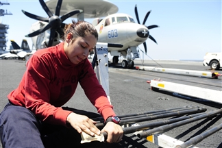 Petty Officer 3rd Class Carolina Franco removes corrosion from the ...