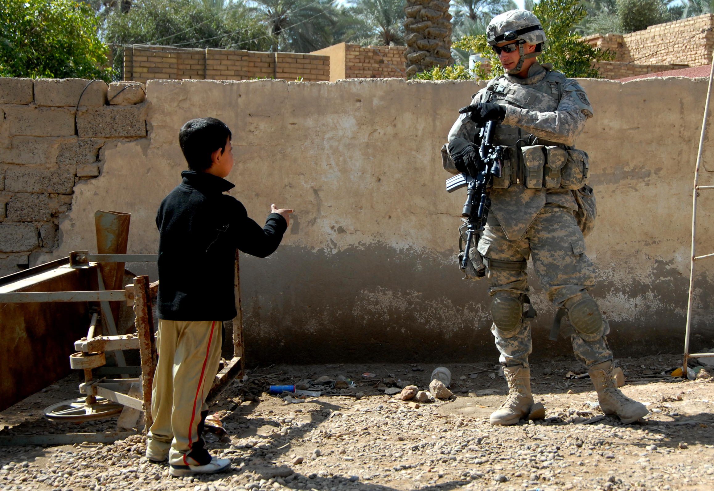 U.S. Army Pfc. George Crowell talks with an Iraqi child at a market in ...