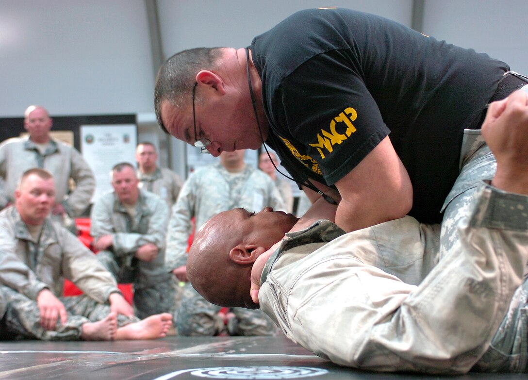 U.S. Army Staff Sgt. Richard Olmeda demonstrate how to employ a cross ...