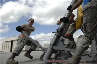 Senior Airman Michelle Metz and fellow airmen rotate a hydraulic jack ...