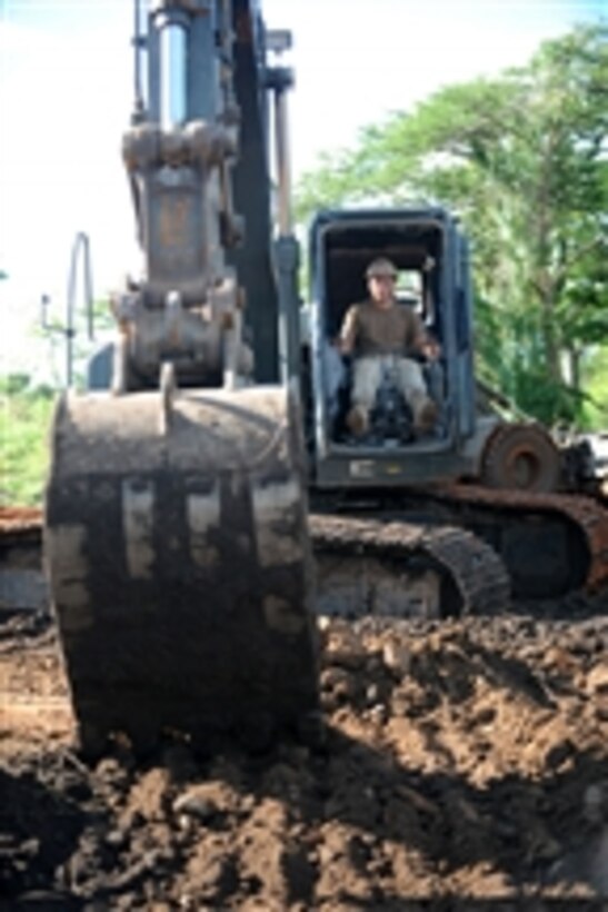 Petty Officer 3rd Class Justian Fordt operates a back hoe. | U.S ...