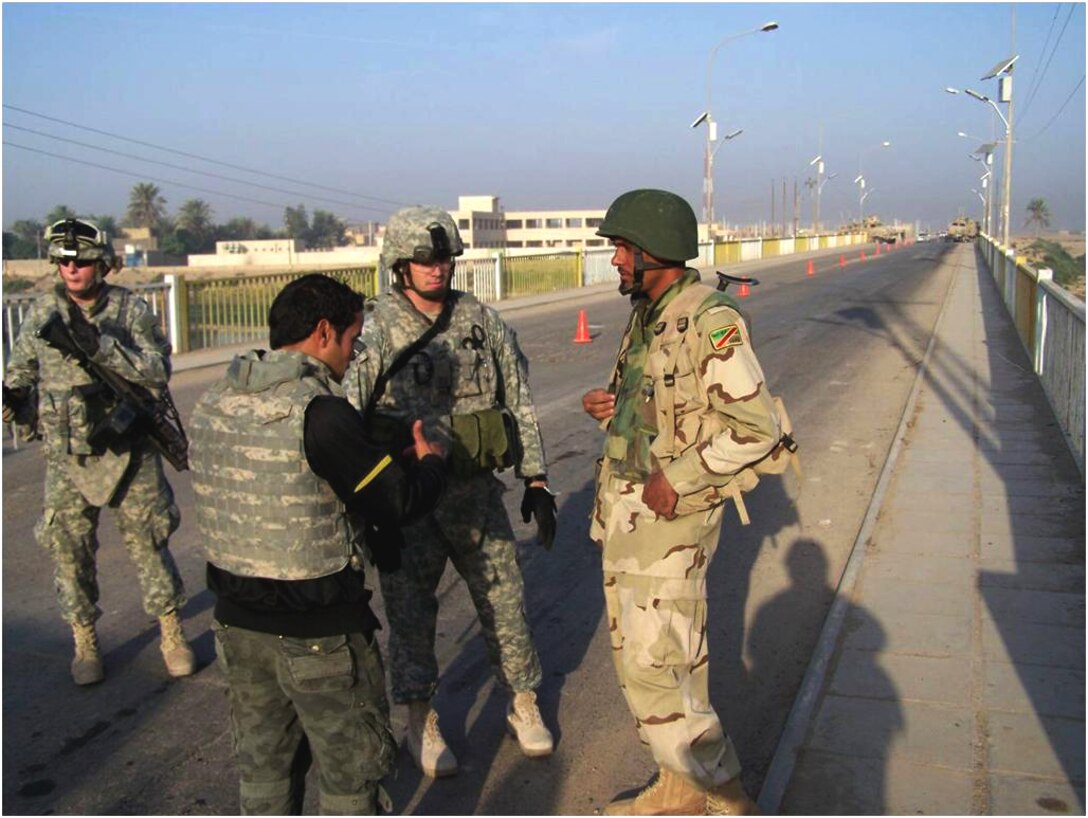 Army Sgt. Ryan Loseby, an Iraqi soldier and their interpreter review ...