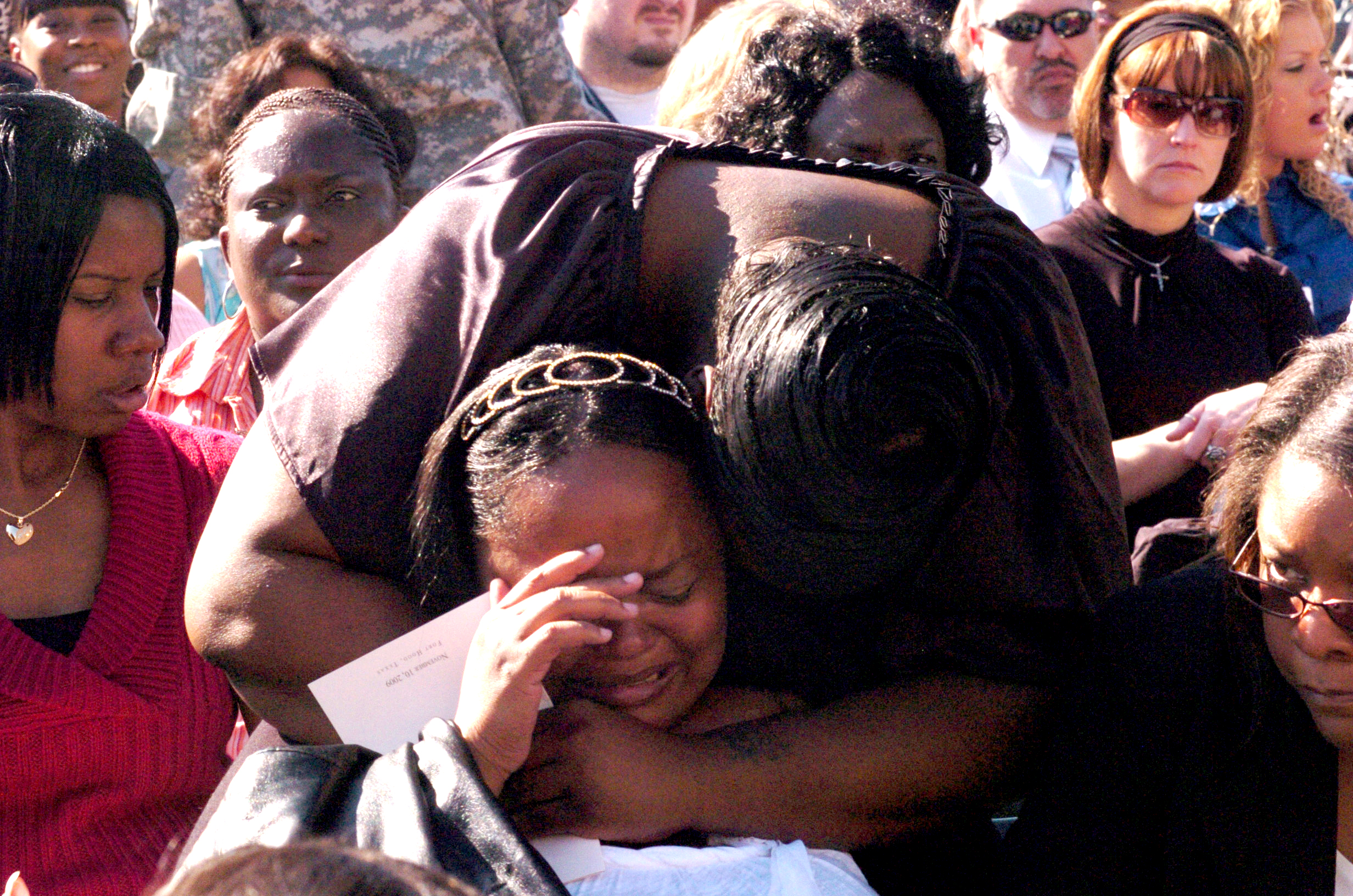 A woman breaks down crying during a memorial ceremony honoring 13 Fort ...