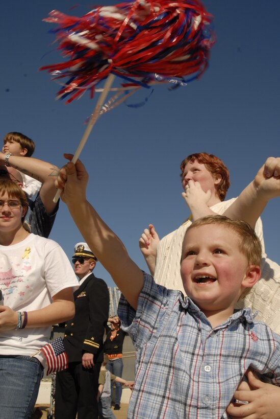 Derek Evans, 3, waves a pom-pom in the air as his father U.S. Navy ...