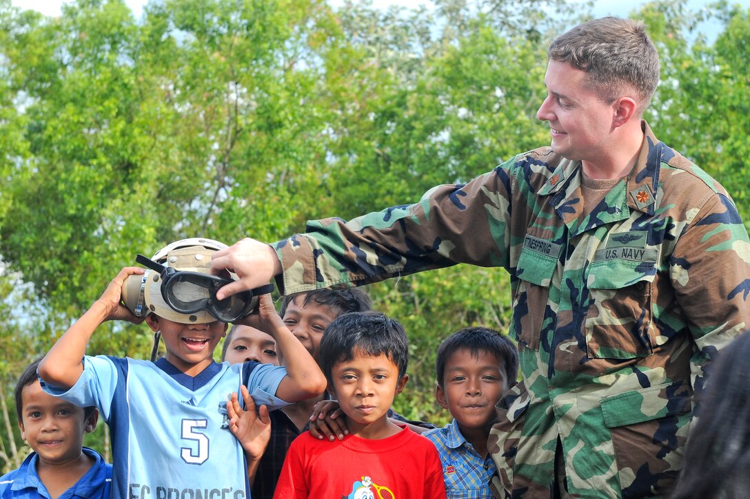 U.S. Navy Lt. Cmdr. Benje Stinespring entertains children in Hula Banda ...