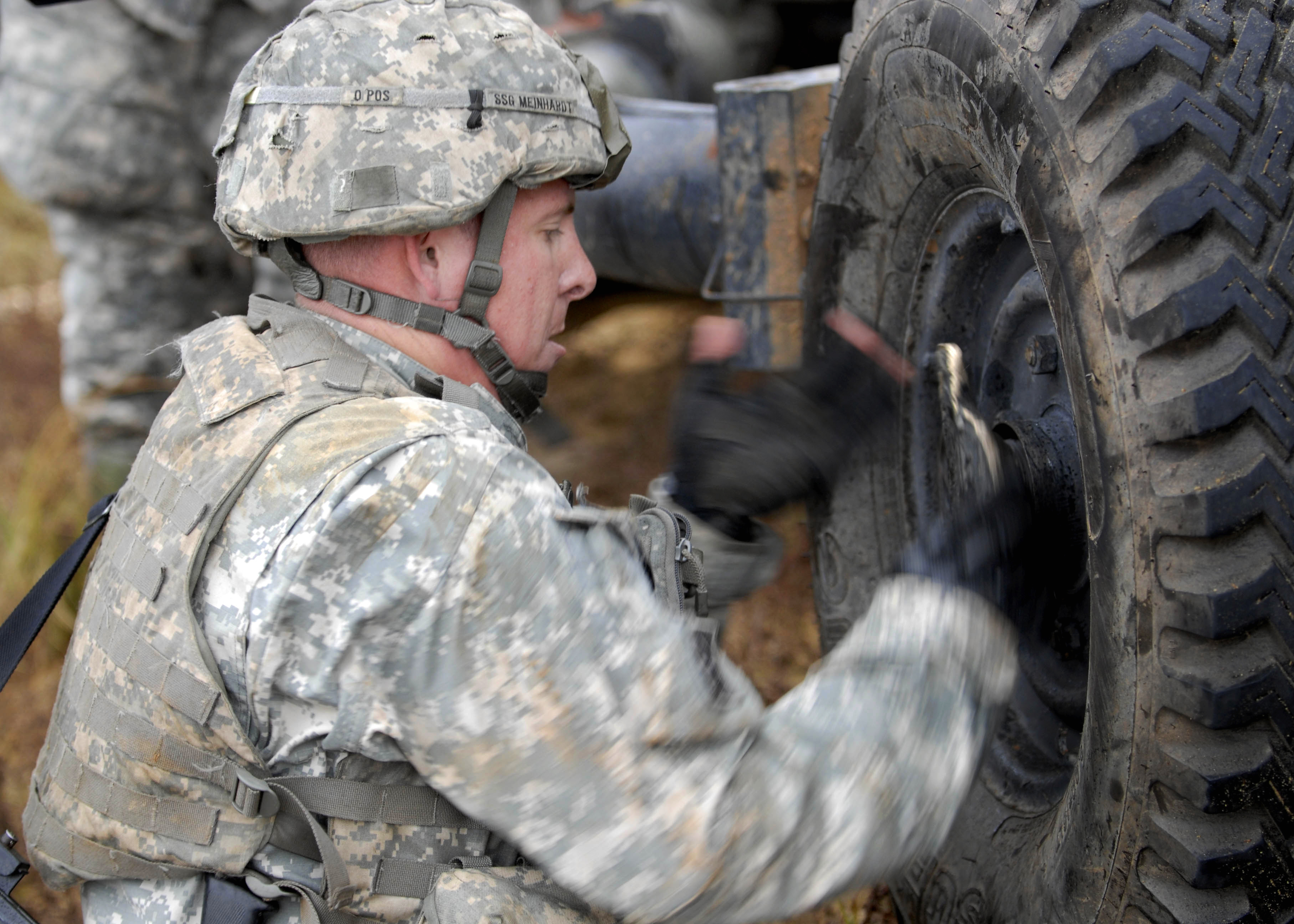 U.S. Army Staff Sgt. Eric Meinhardt adjusts one of the howitzer's tires ...