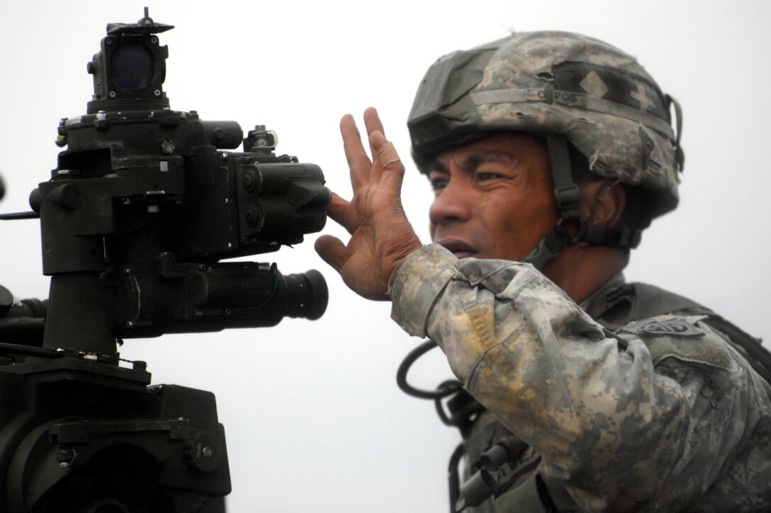 U.S. Army Sgt. Haseni Lave aims the howitzer to fire during a training ...