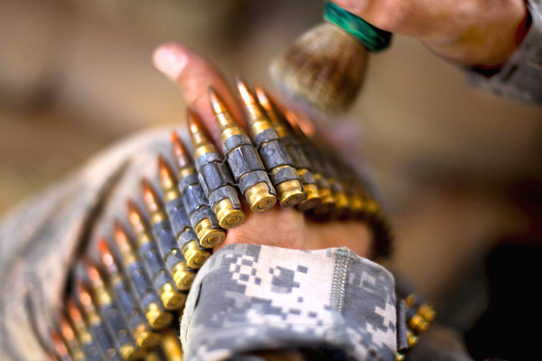 U.S. Army Joshua Spann cleans a belt of 7.62 mm Nato rounds for his ...