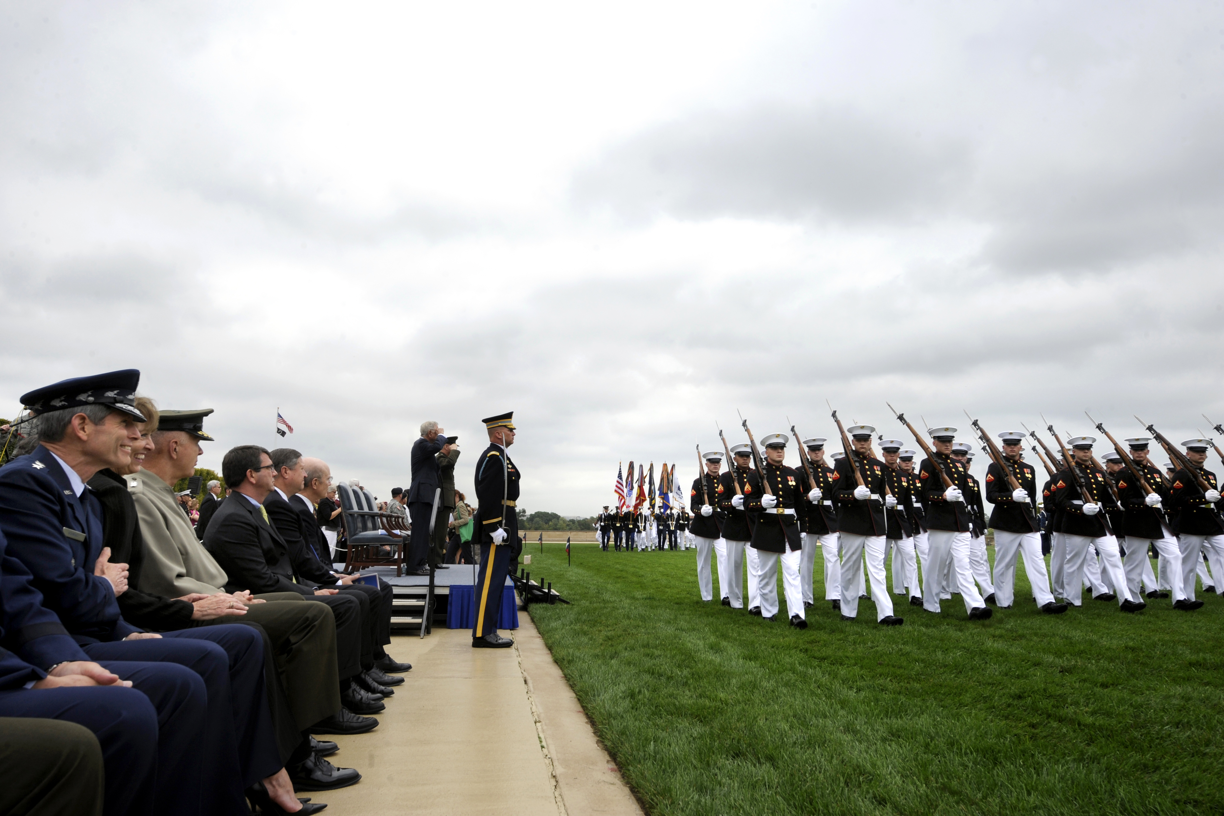 Defense Department officials watch a troop march-in-review as part of ...