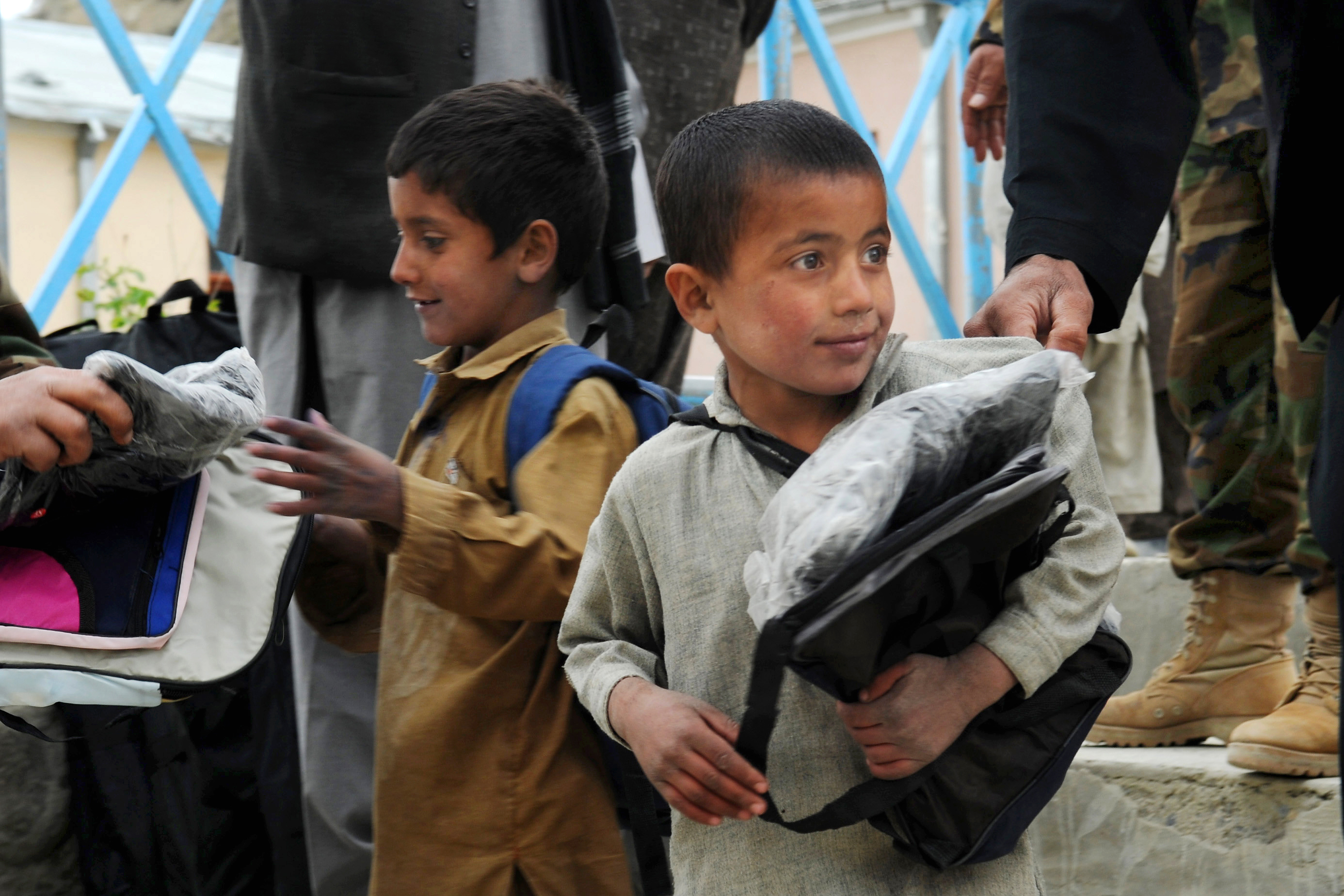 Children pick up school supplies from Afghan National Army soldiers ...