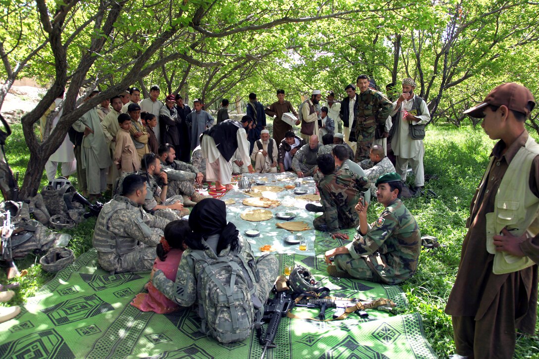 U.S. Army and Afghan army soldiers sit with village elders that chose ...