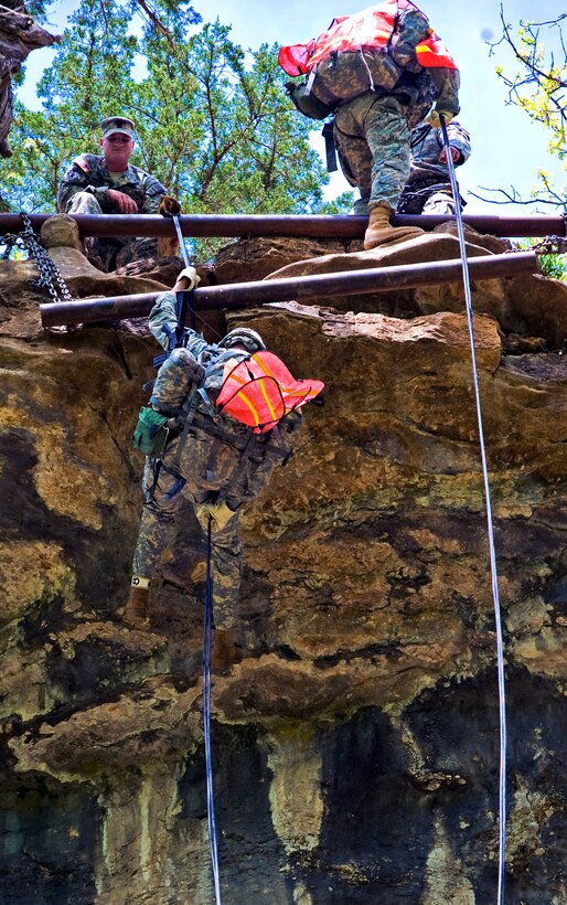 Two U.S. Army soldiers rappel over the side of a cliff as they begin ...