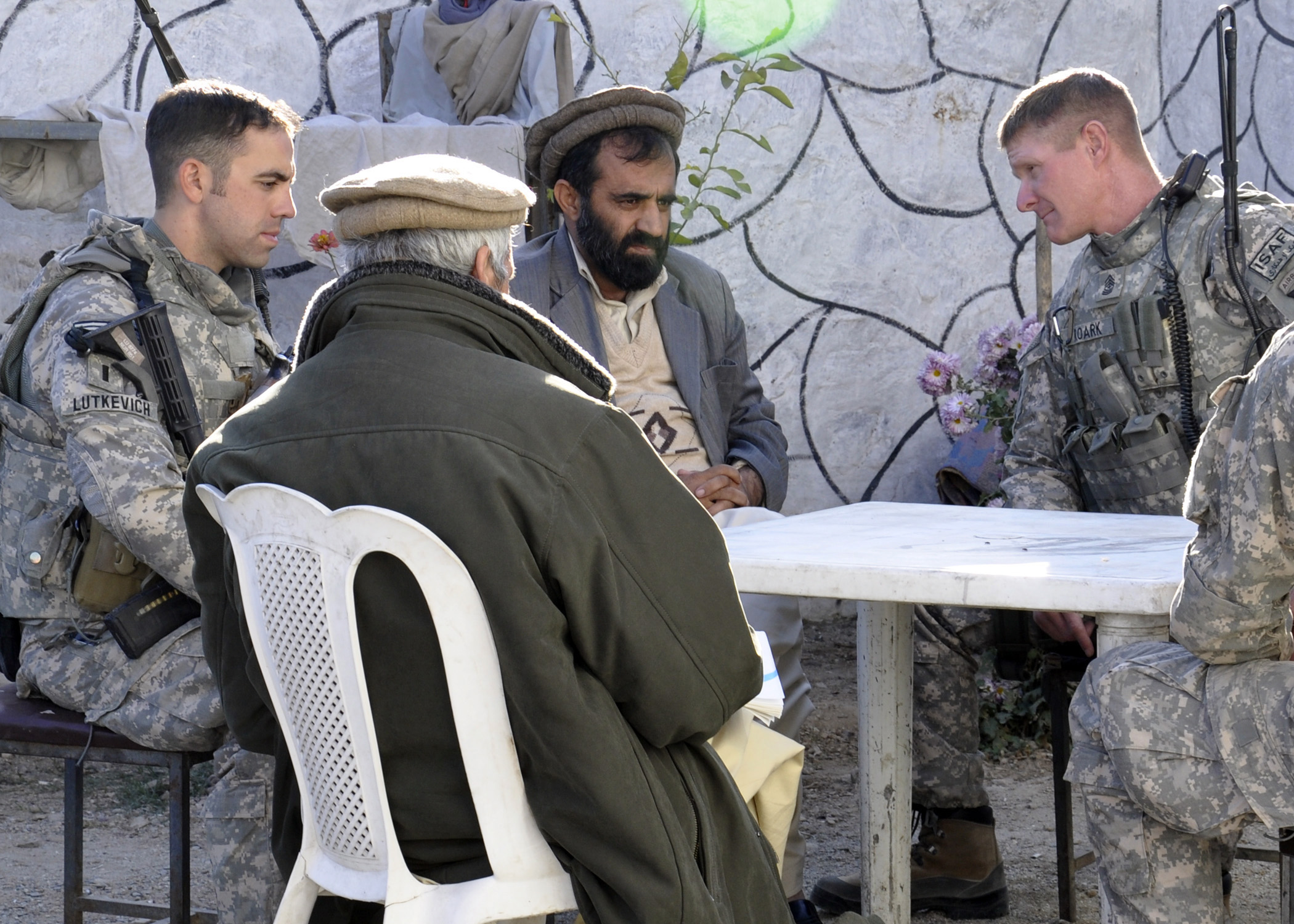 U.S. Army Sgt. Maj. Jason Roark, right, talks to the leader of the ...