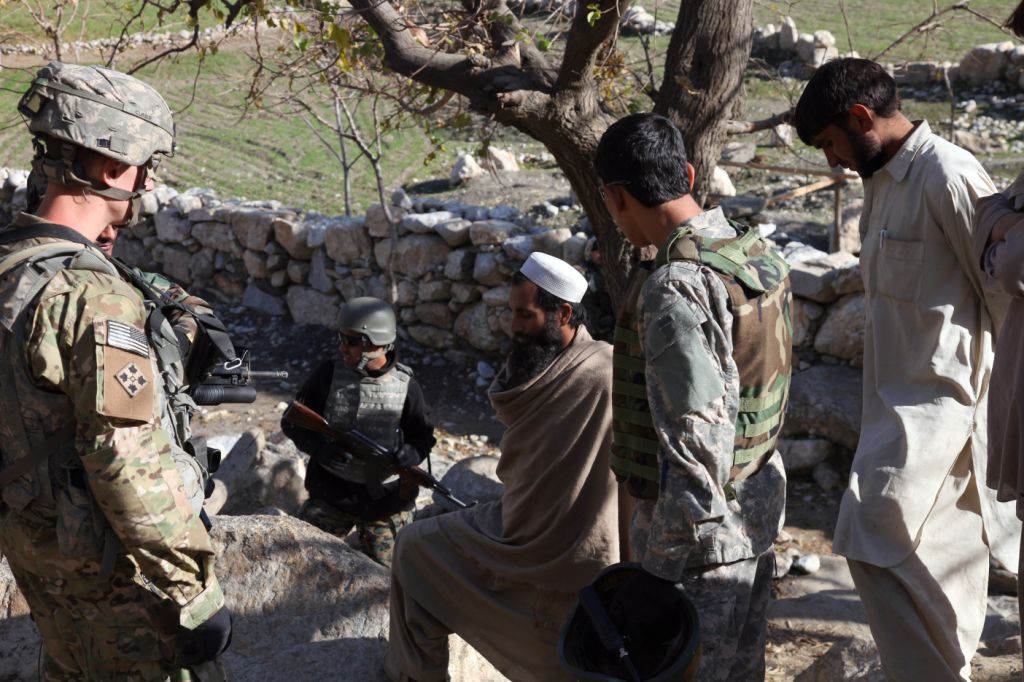 U.S. Army 1st Lt. John Cumbie, left, speaks with a village elder during ...