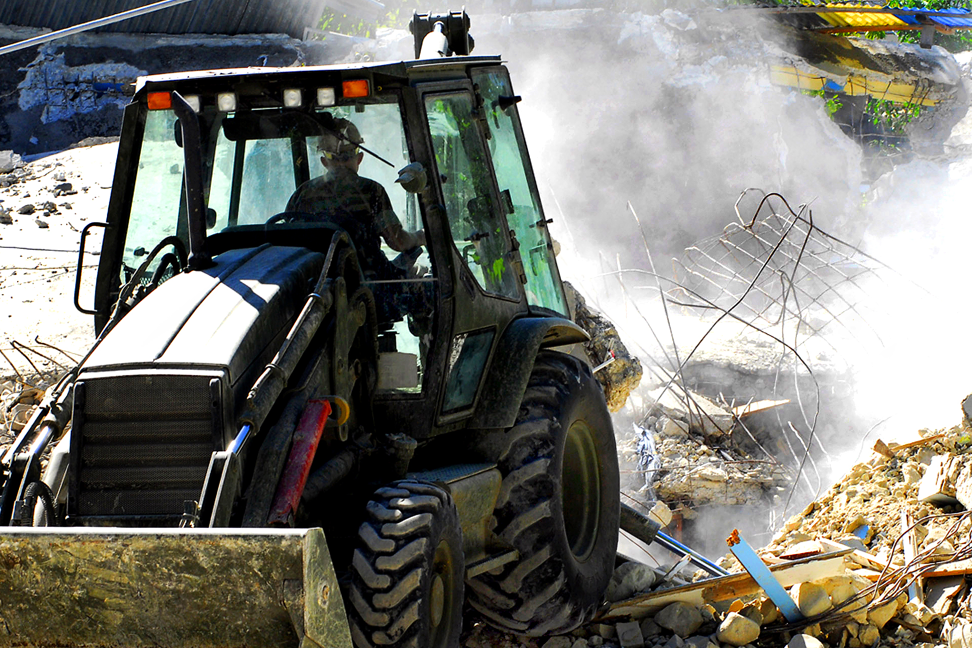 A U.S. Navy Seabee removes rubble from a collapsed church in Baie De ...