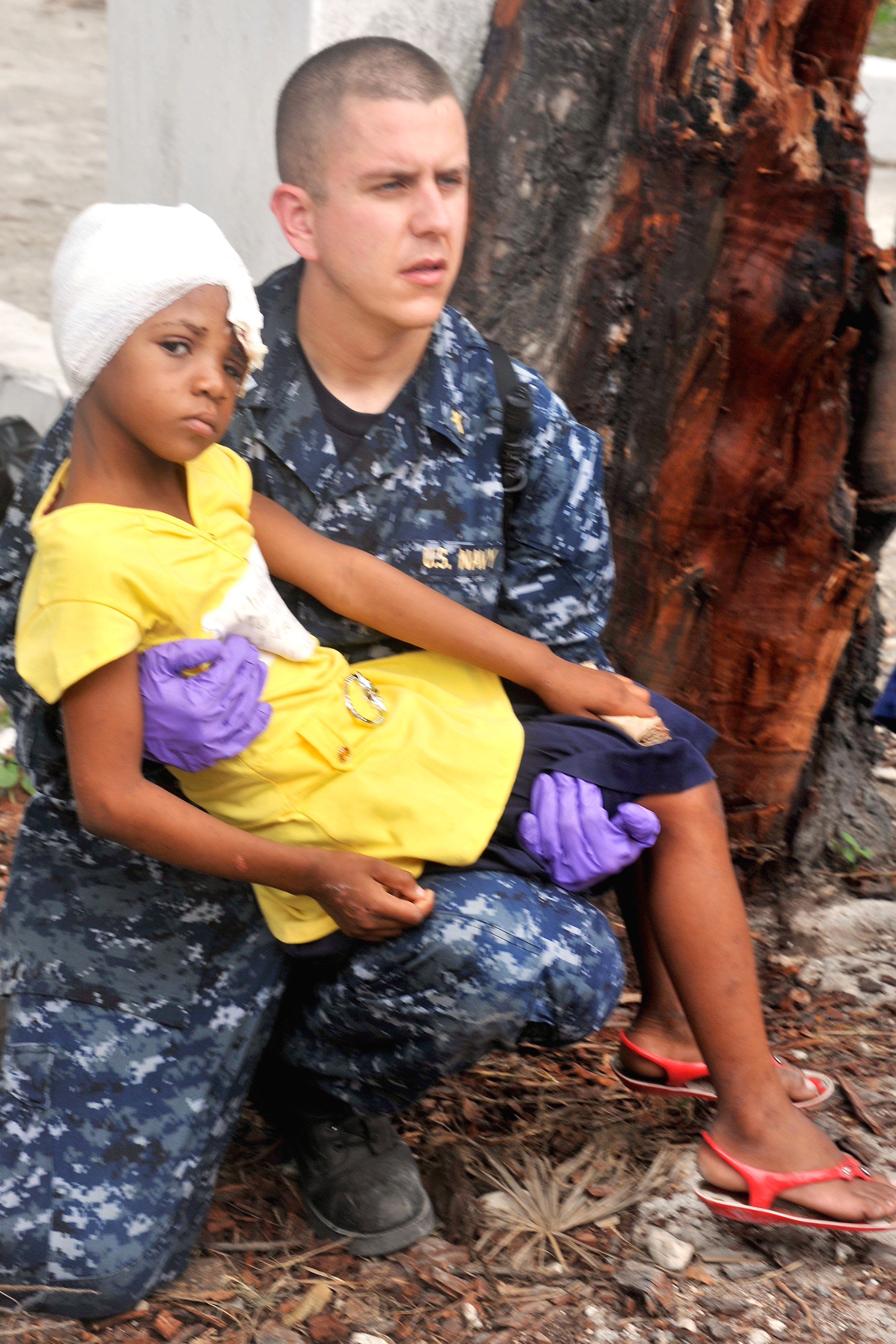 U.S. Navy Lt. Marlin Williams, holds an injured Haitian girl as he ...