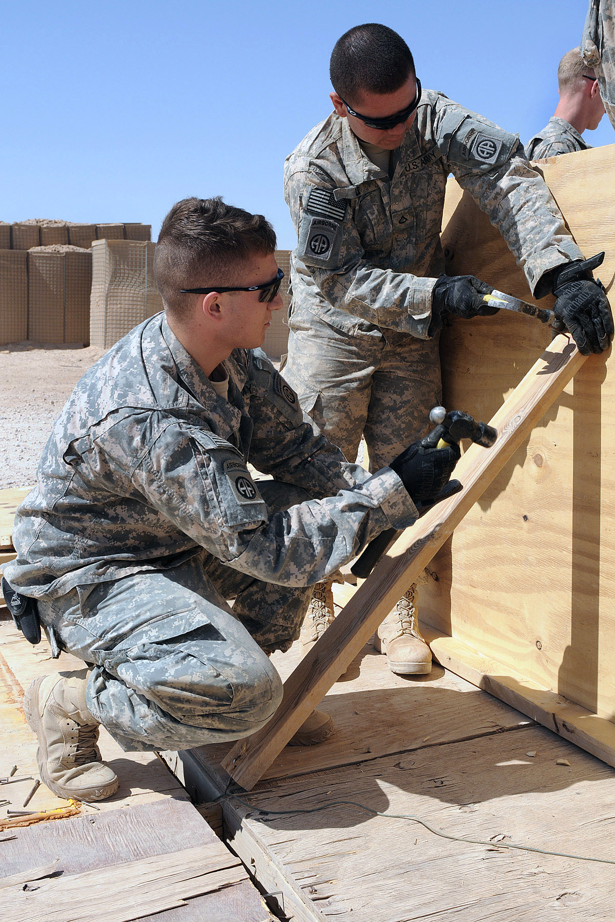 U.S. Army Spc. Christopher Brown, left, holds a board steady for Pfc ...