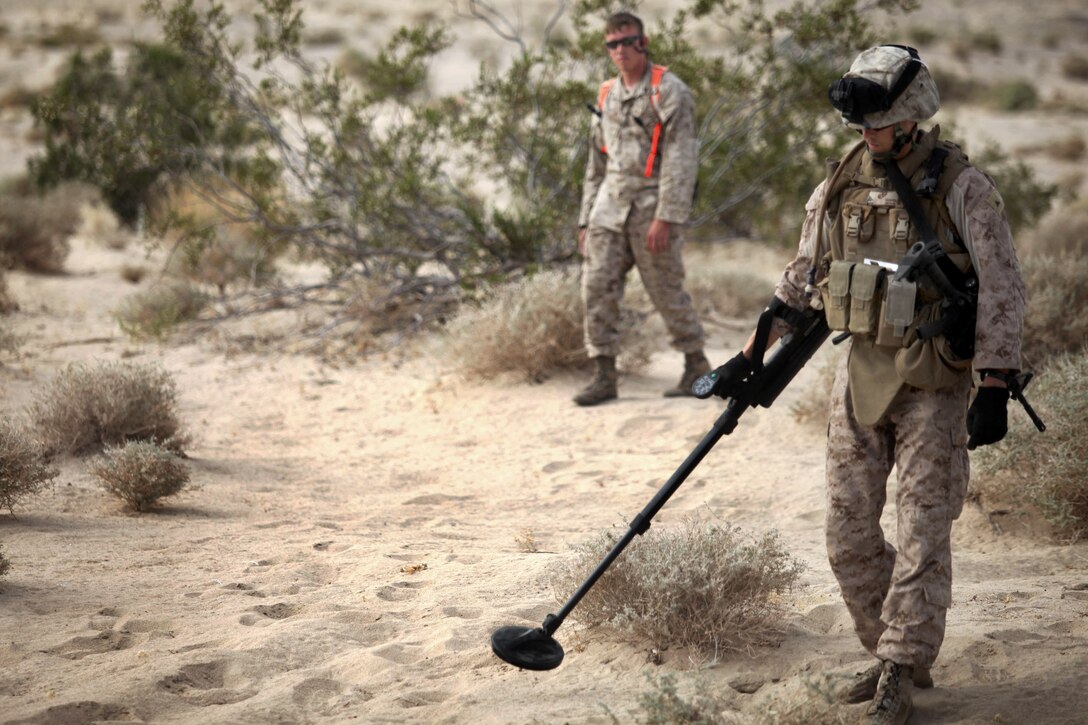 A U.S. Marine uses a mine detector during Enhanced Mojave Viper, a ...
