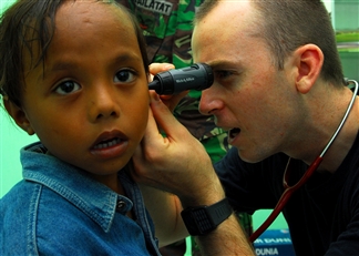 Lt. Timothy Chinnock examines a child’s ear during a medical civic ...