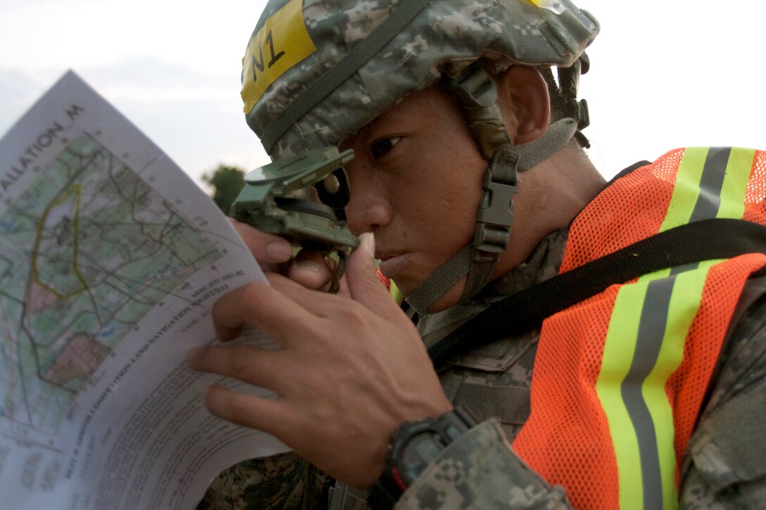 U.S. Army Sgt. 1st Class Marc T. Facunla shoots an azimuth using the ...