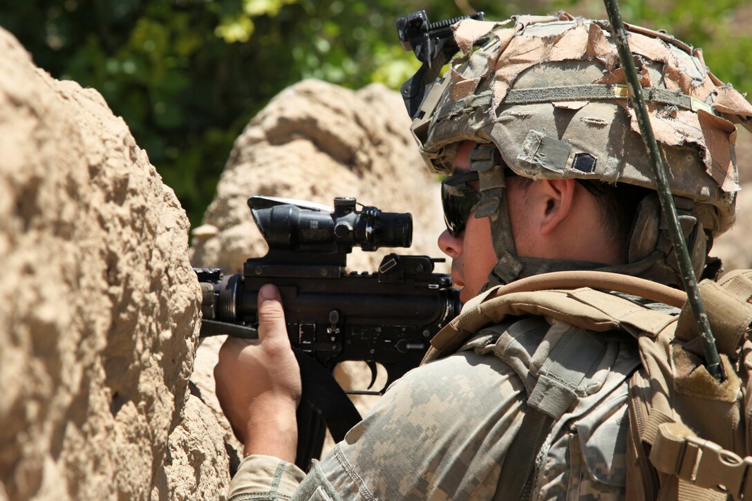 A U.S. Army cavalryman uses the scope on his rifle to keep an eye on ...