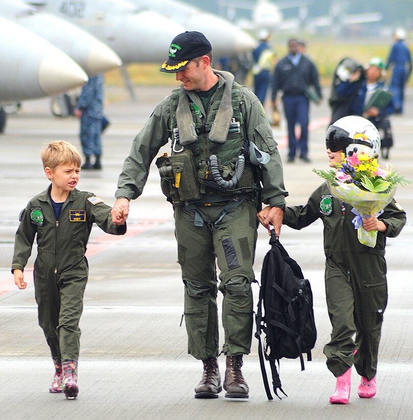U.S. Navy Cmdr. William Gotten walks with his son and daughter along ...
