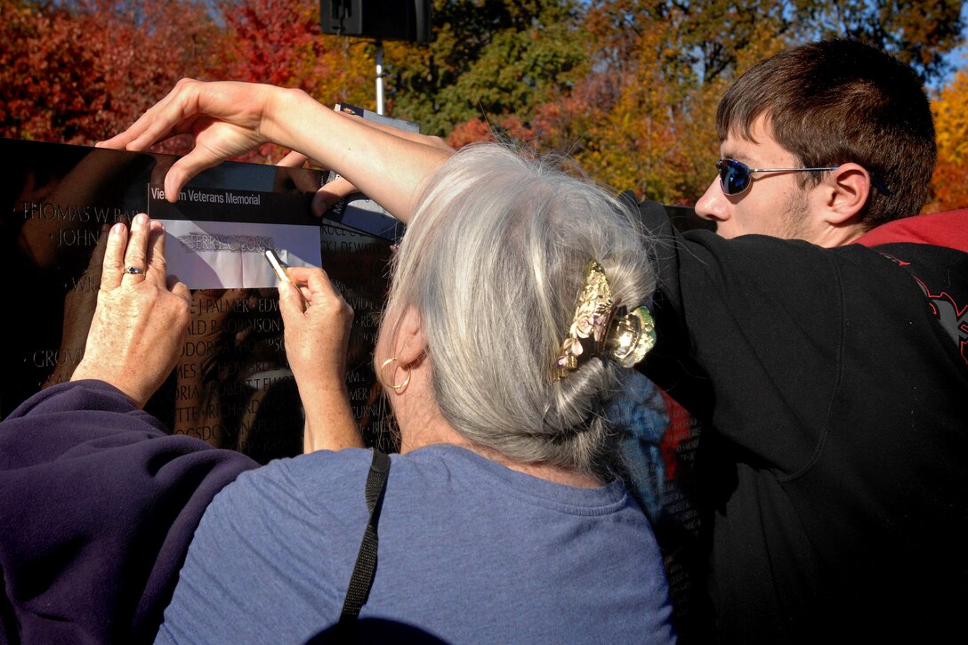 Rebecca Reid rubs the name of Terry C. Corson onto a piece of paper at ...